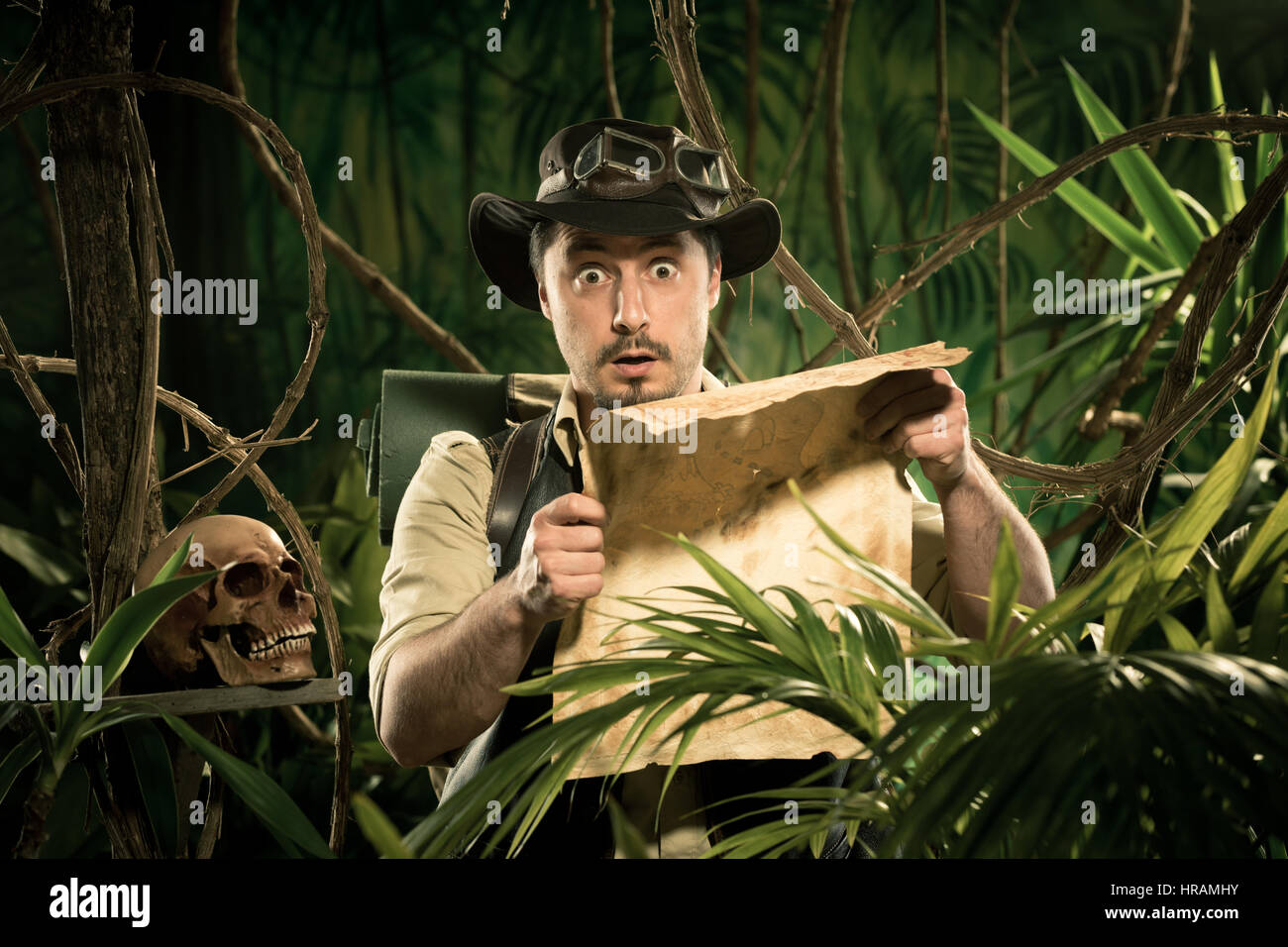 Young explorer lost in jungle examining an old map Stock Photo - Alamy