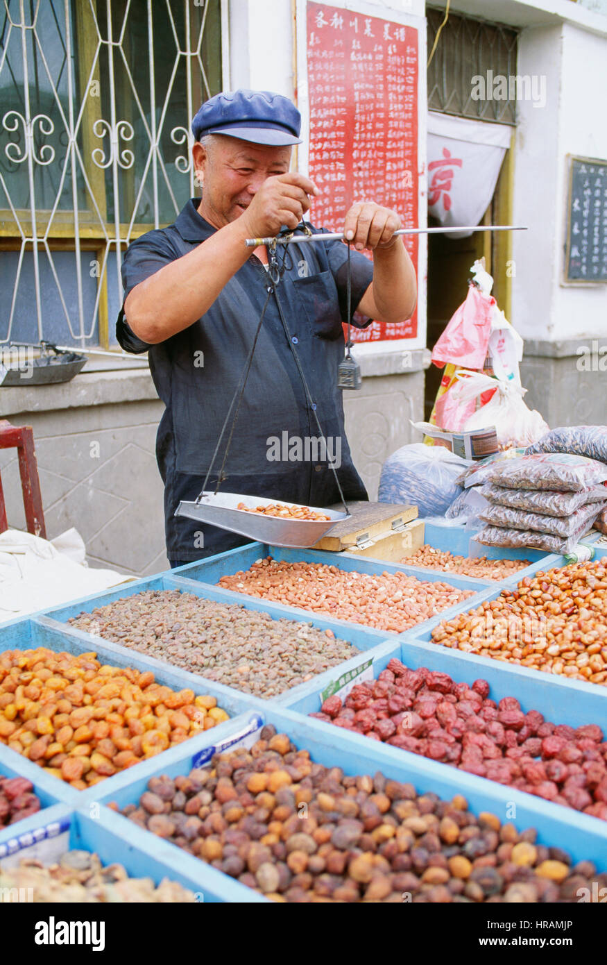 Chinese Man selling nuts and dried fruit at a street market, Dunhuang ...