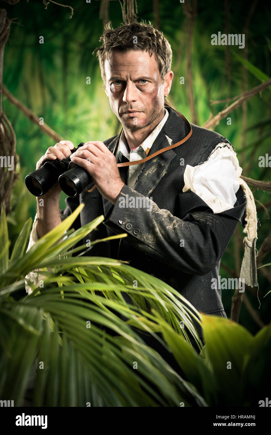 Confident businessman holding binoculars and exploring jungle Stock ...