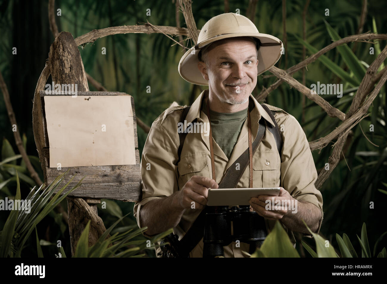 Colonial style adventurer with digital tablet exploring jungle ...
