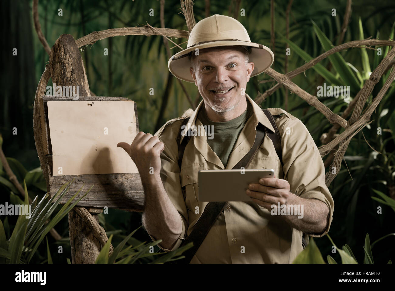 Colonial style adventurer with digital tablet exploring jungle ...