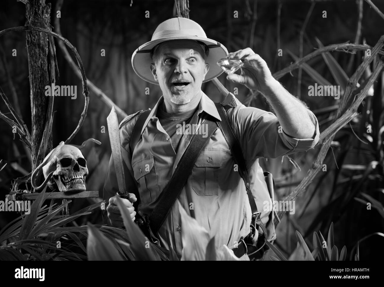 Smiling adventurer finding a huge diamond in the jungle with explorer ...