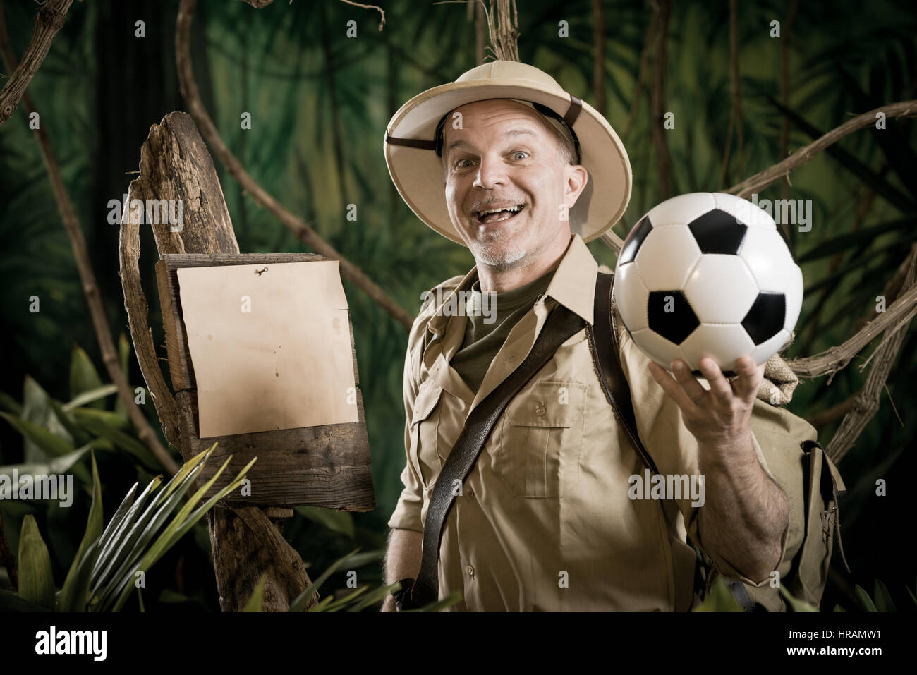 Smiling explorer in the jungle holding a soccer ball Stock Photo - Alamy
