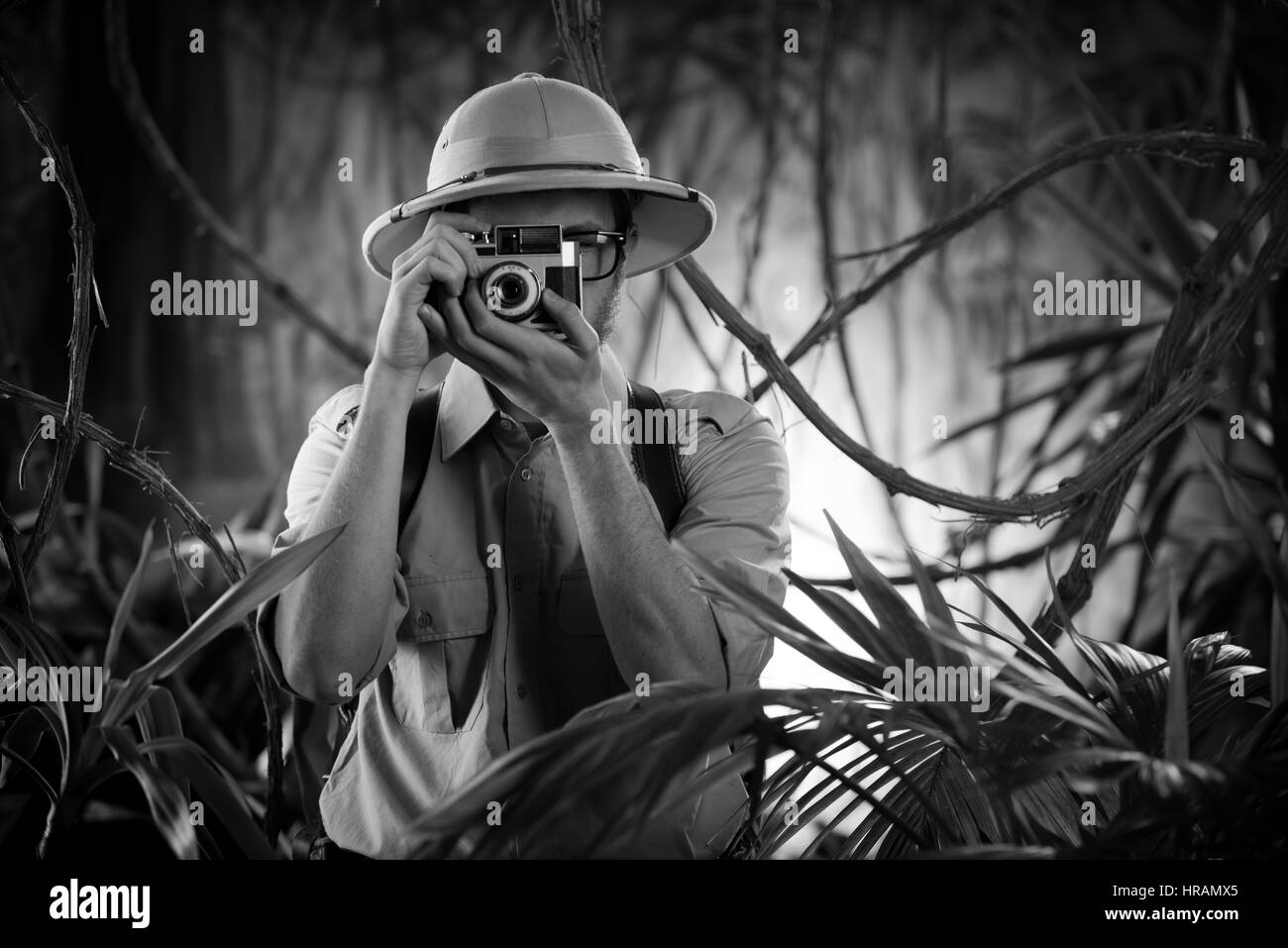 Young explorer in the jungle taking pictures with vintage camera Stock ...
