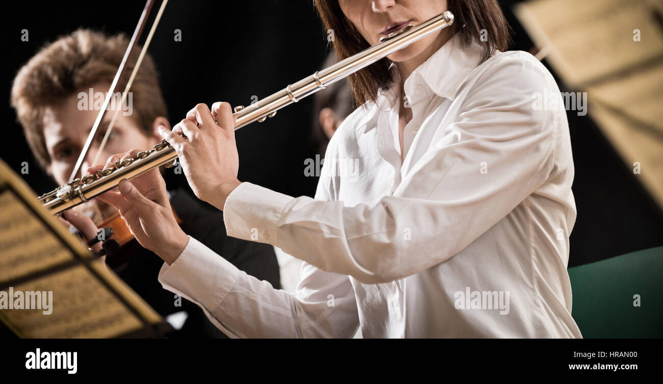 Elegant female flutist performing on hi-res stock photography and ...