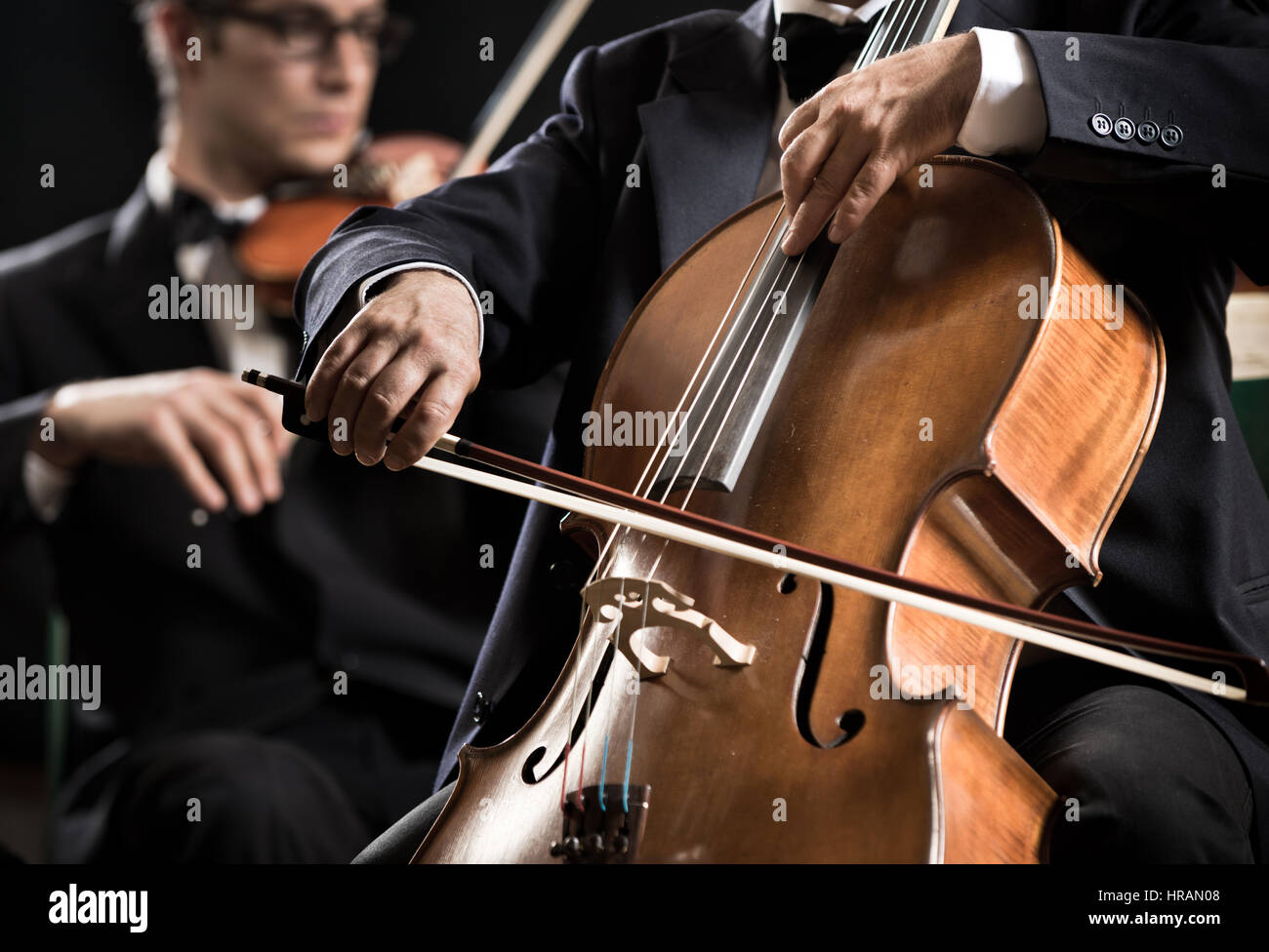 Cello professional player with symphony orchestra performing in concert ...