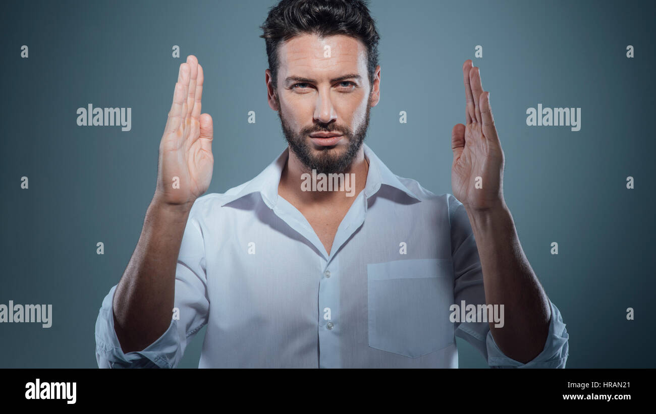Handsome young man with raised hands, measure concept Stock Photo - Alamy
