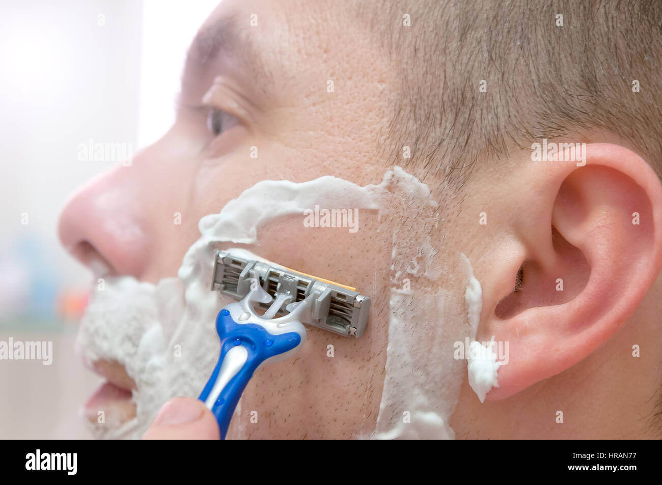 handsome man shaving his beard in bathroom Stock Photo - Alamy