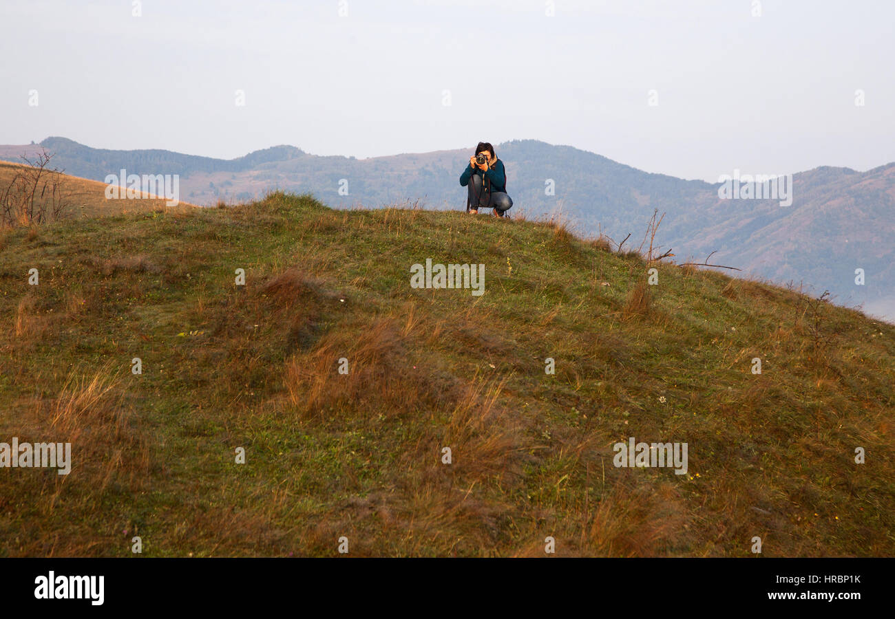female photographer at sunrise, misty mountains, Romania Stock Photo ...