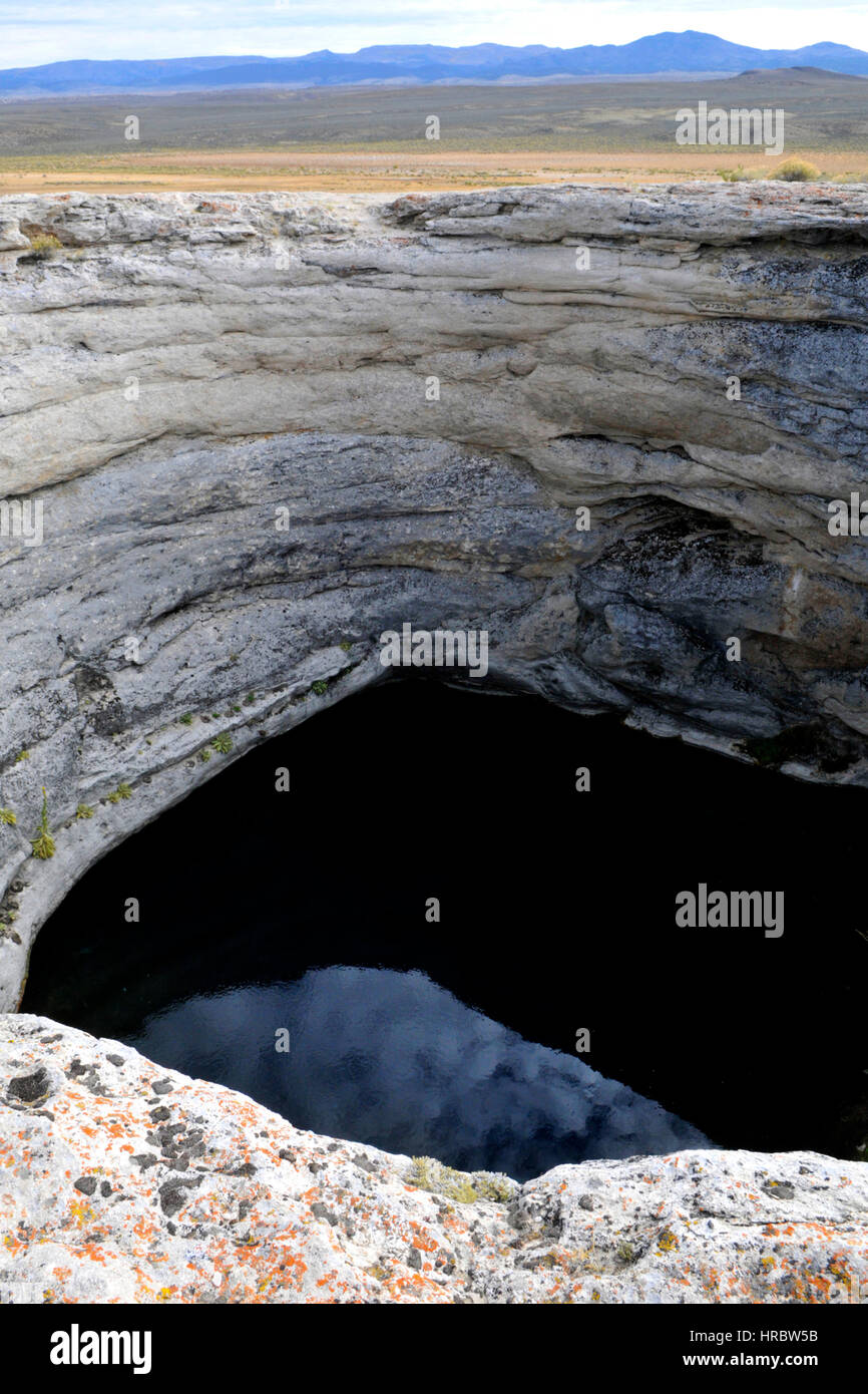 Vertical shot of a deep natural hot spring pool, Diana's Punch Bowl, in ...