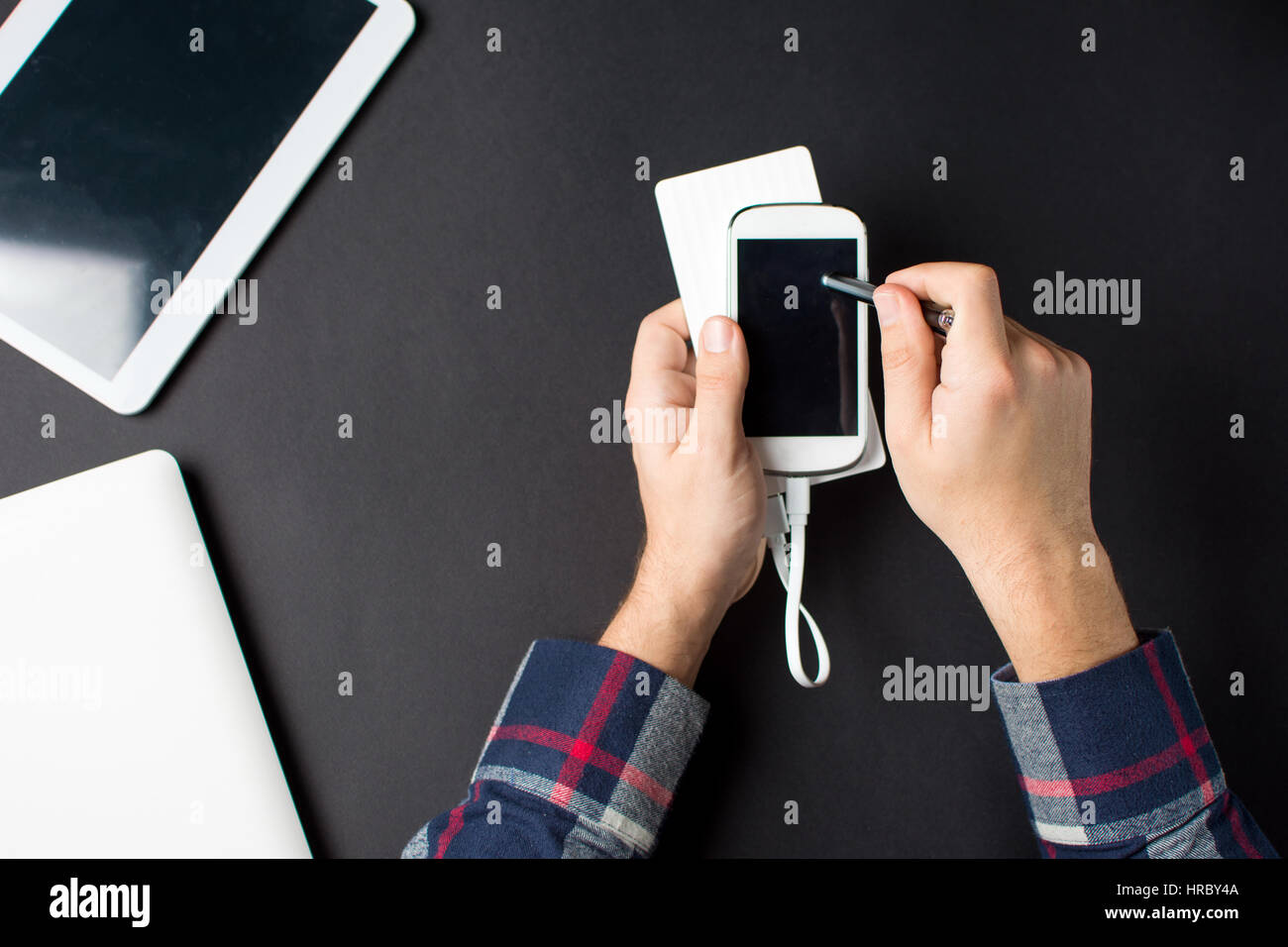 Man using a white cellphone connected to a power bank Stock Photo - Alamy