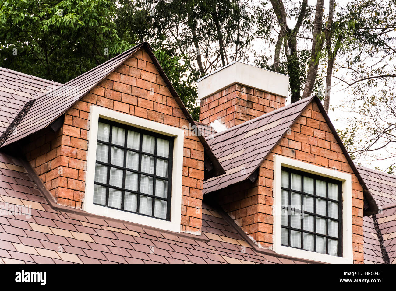 Triangular end of a roof with two windows Stock Photo - Alamy