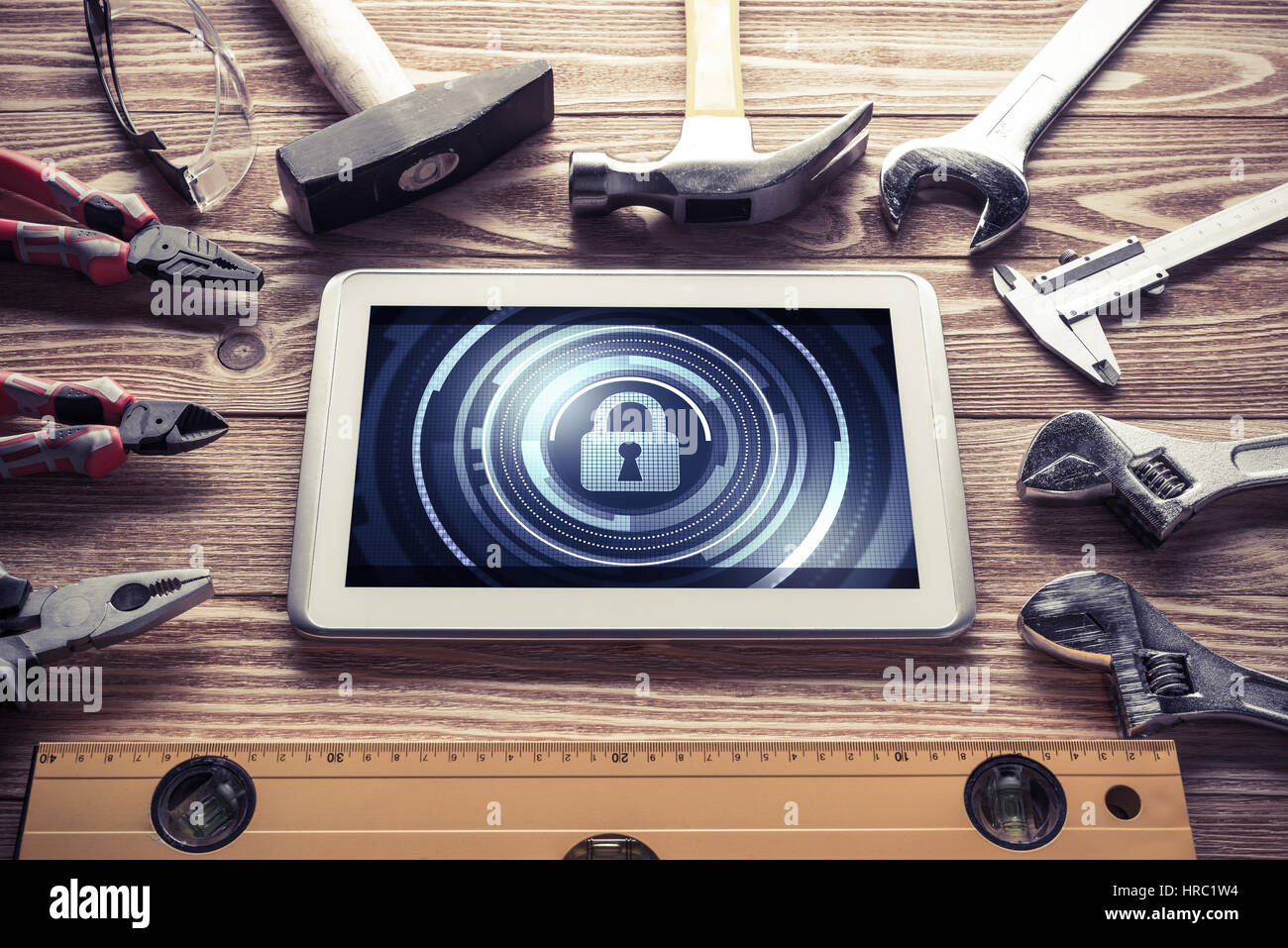 Tablet pc with security concept on screen and industrial tools around ...