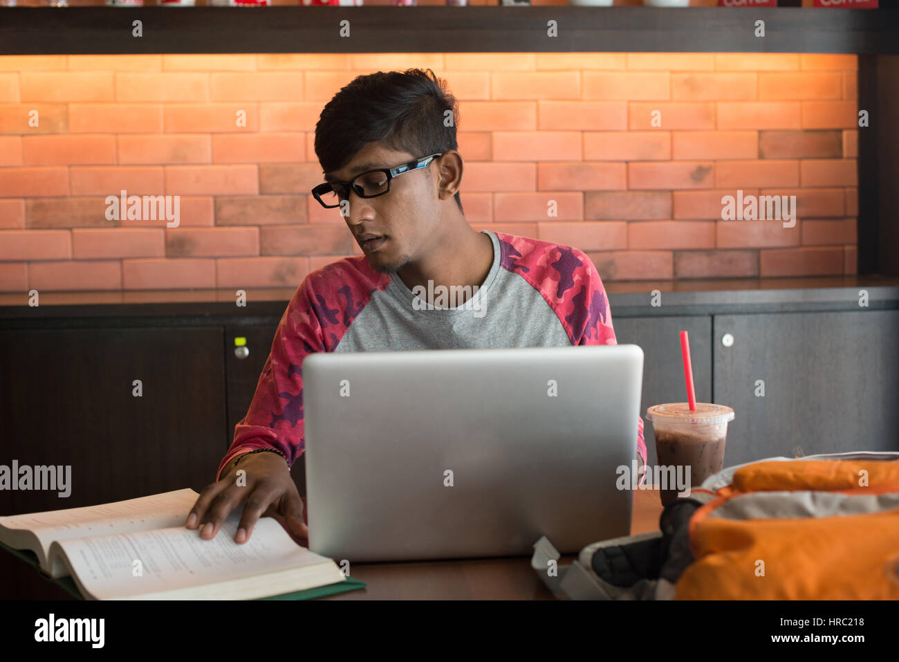 indian teenage male drinking coffee doing homework at cafe Stock Photo ...