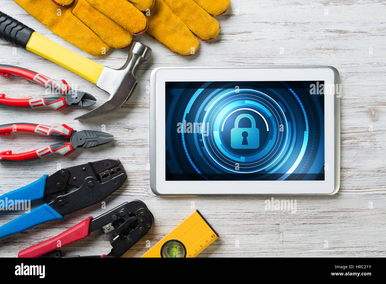 Tablet pc with security concept on screen and industrial tools around ...