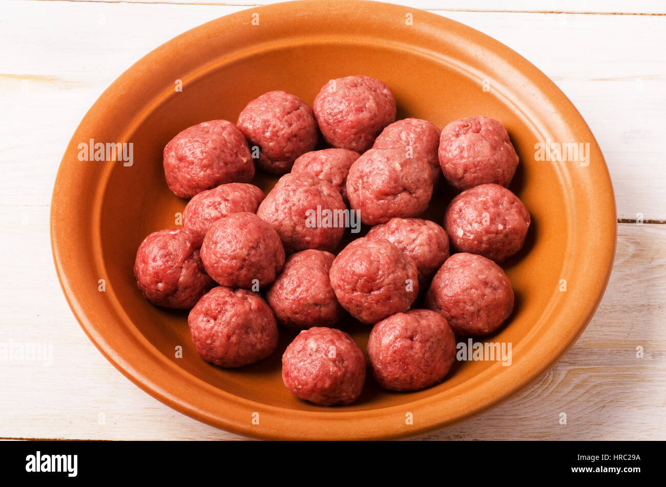 Raw meatballs in plate on a white wooden table background Stock Photo ...