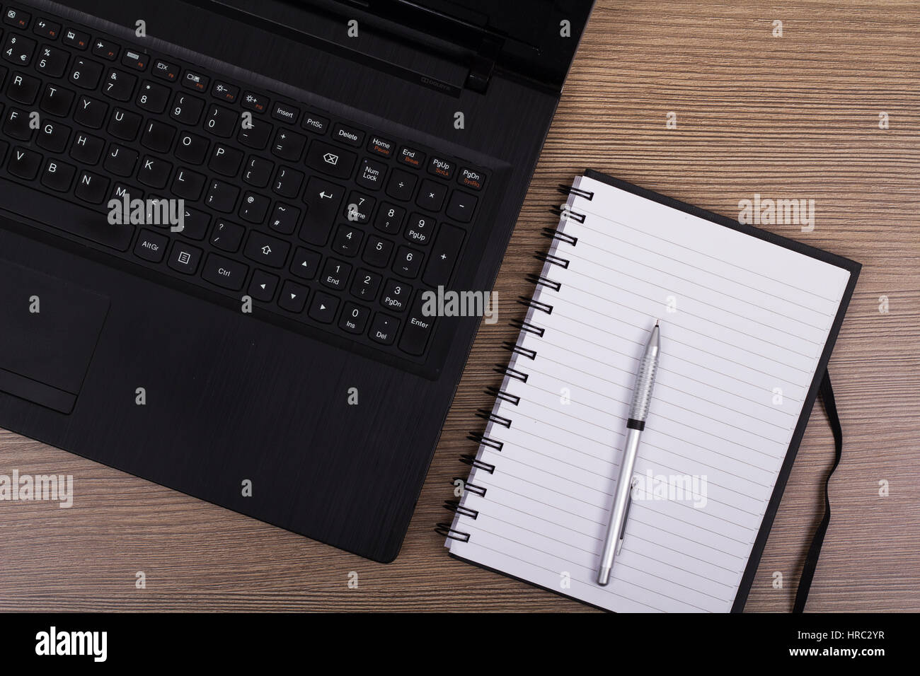 Lay flat image of an open notebook and laptop on a wooden surface Stock ...