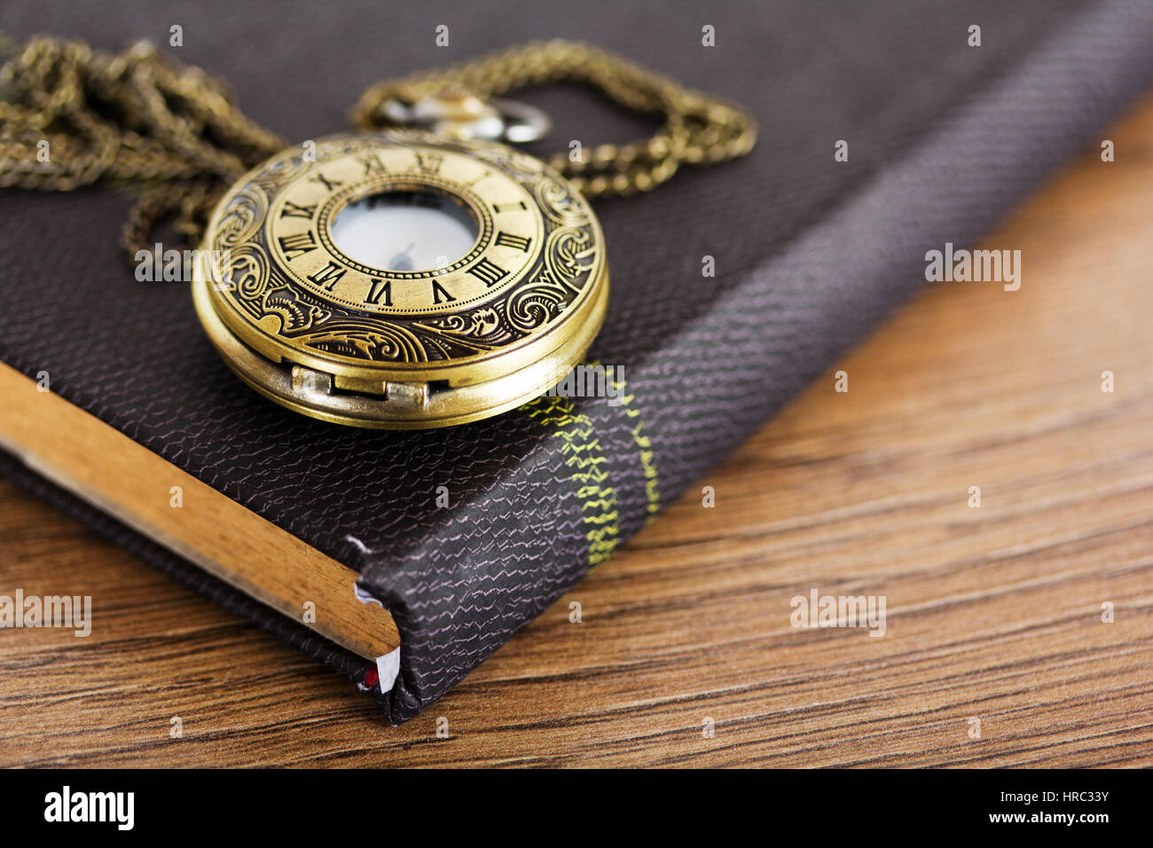 Pocket watch and book against a rustic wooden background Stock Photo ...