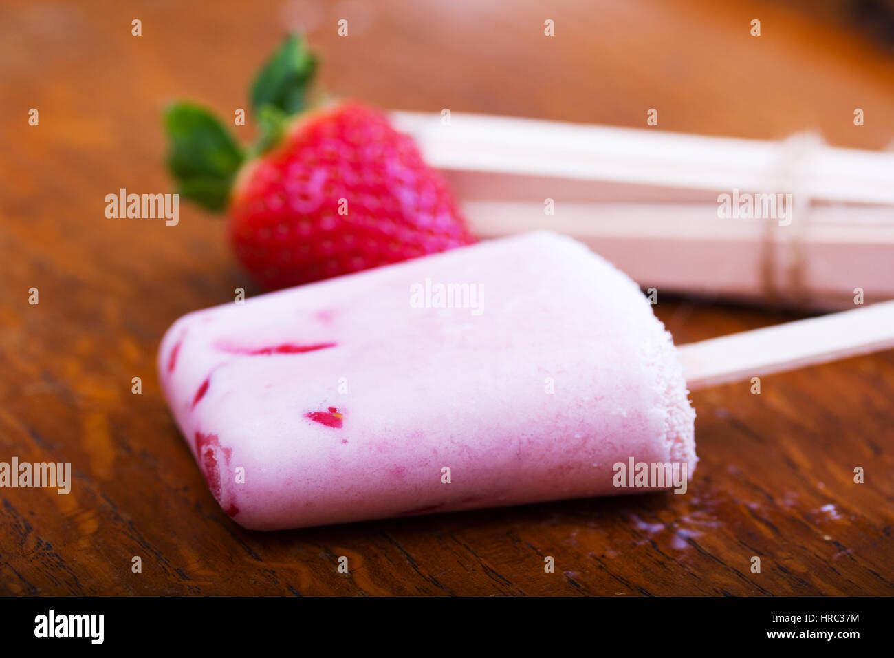 Homemade strawberry ice lolly on a rustic background Stock Photo - Alamy