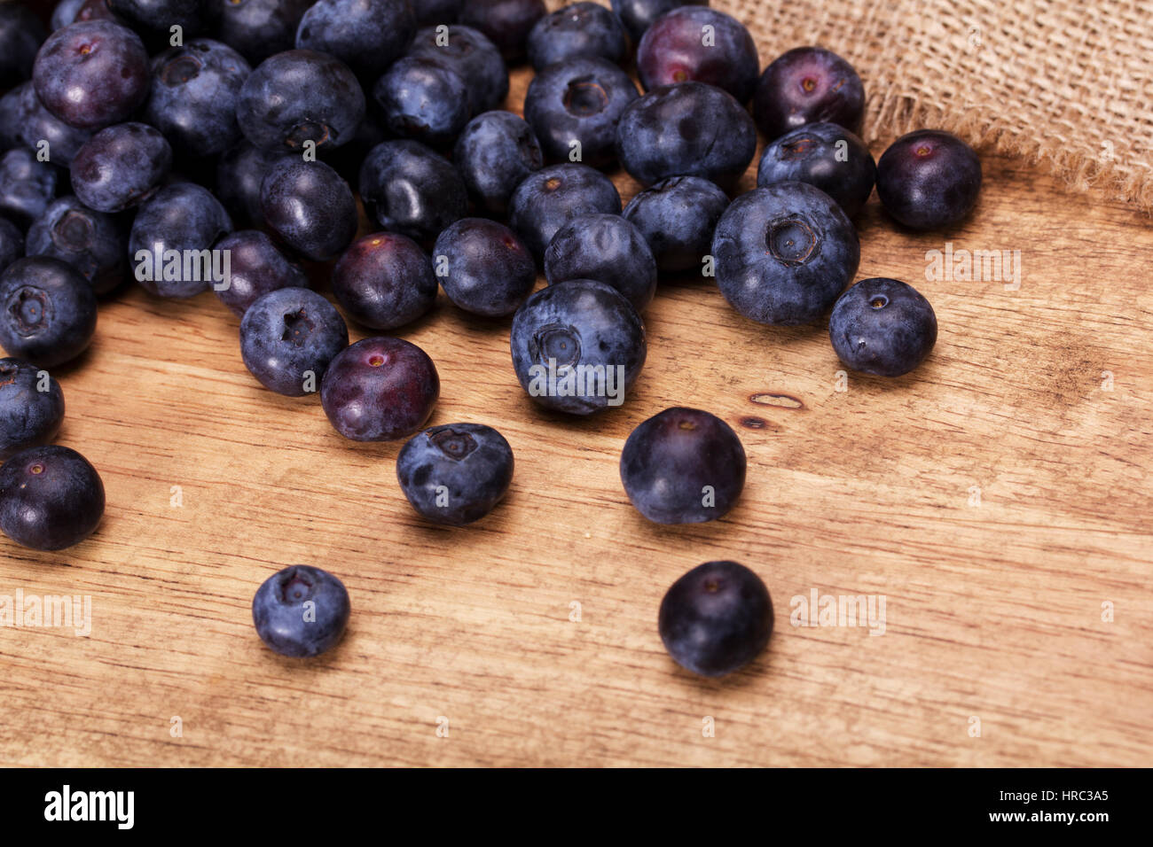 Blueberries spilt over a rustic wooden background Stock Photo - Alamy