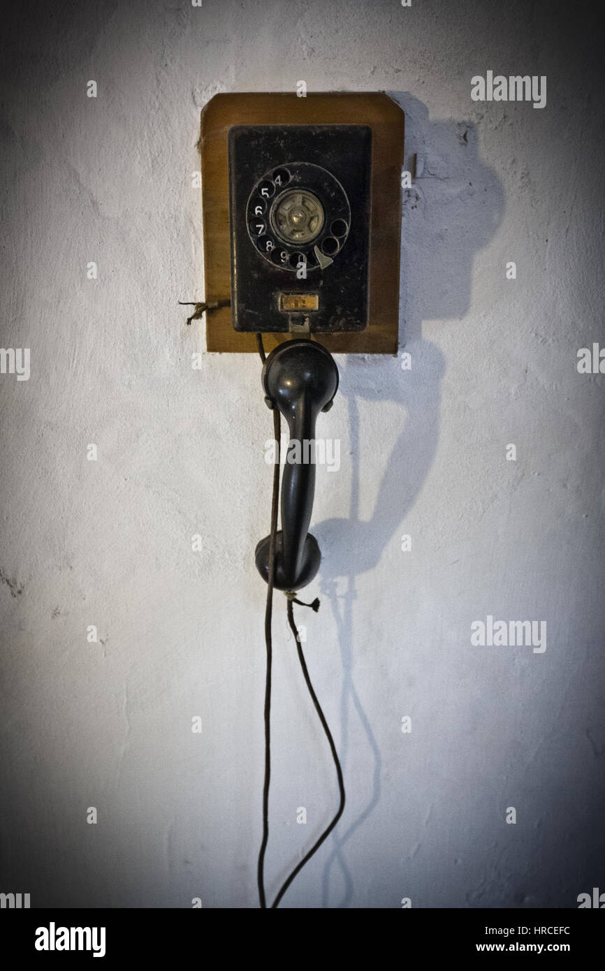 Old vintage rotary telephone box with the handset hanging below mounted ...
