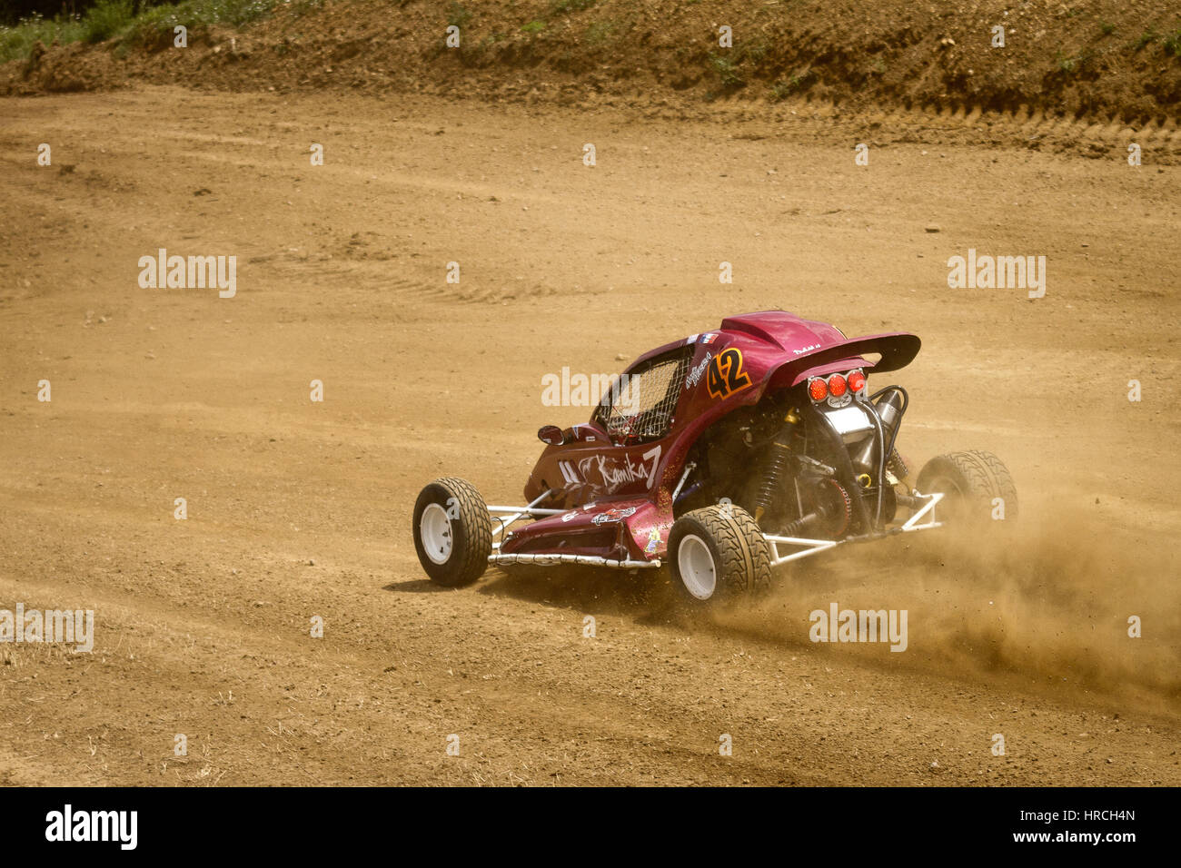 Red off-road buggy racing car raising dust on dry dirt track, shot form ...