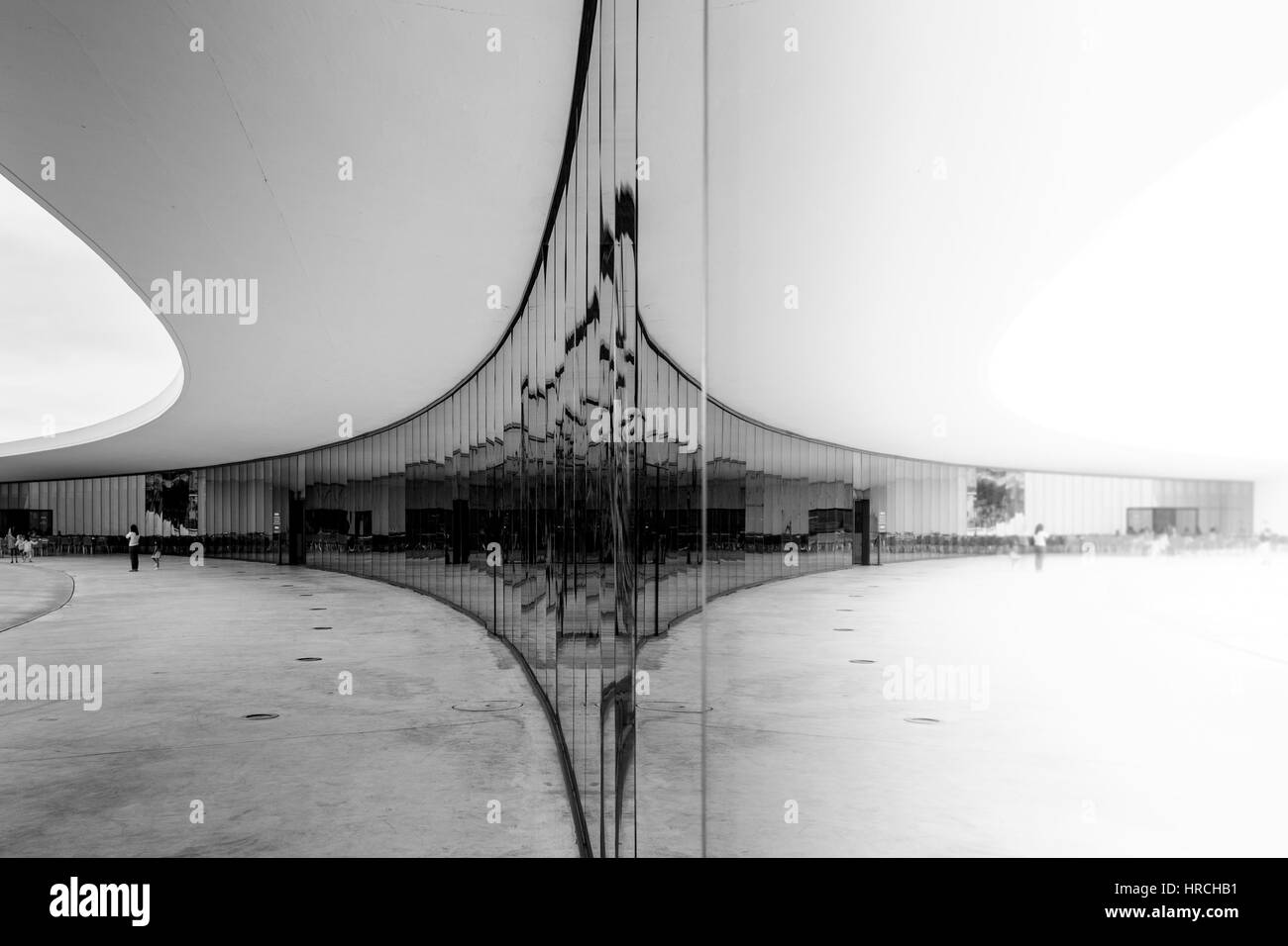 Bent mirror wall of museum in Spain with reflection of spacious hall in ...