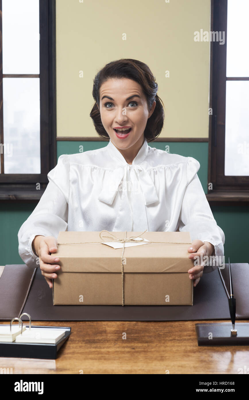 Excited vintage woman receiving a surprise box at office Stock Photo ...