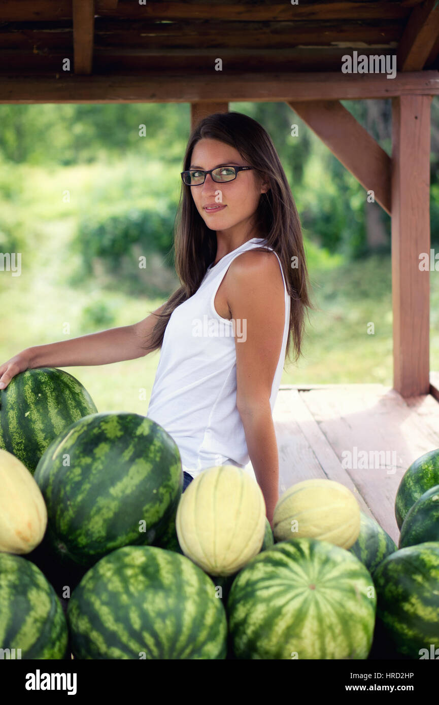 Beautyful young woman selling melon and smiles Stock Photo - Alamy