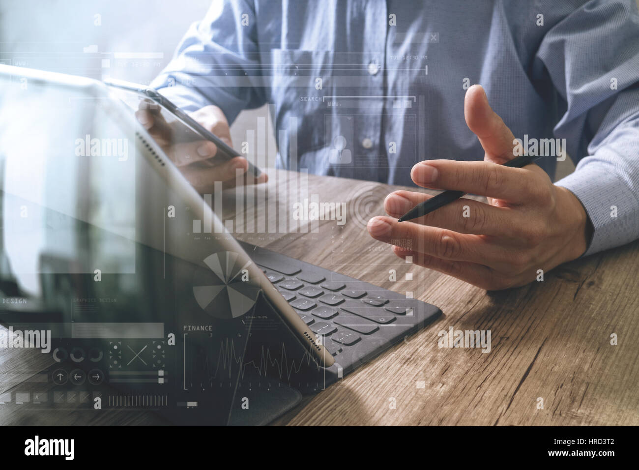 success businessman hand using stylus pen,digital tablet docking smart keyboard on wooden desk ...