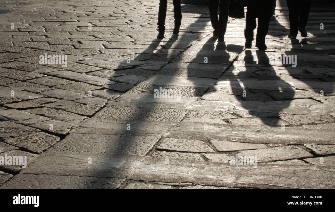 Silhouettes of people on the cobblestone pavement Stock Photo - Alamy
