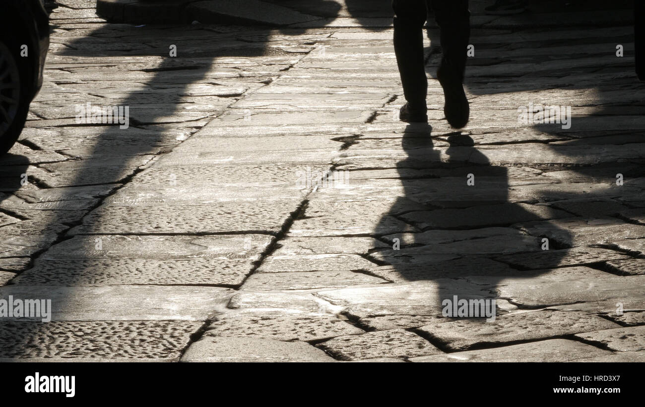 Silhouettes of people on the cobblestone pavement Stock Photo - Alamy