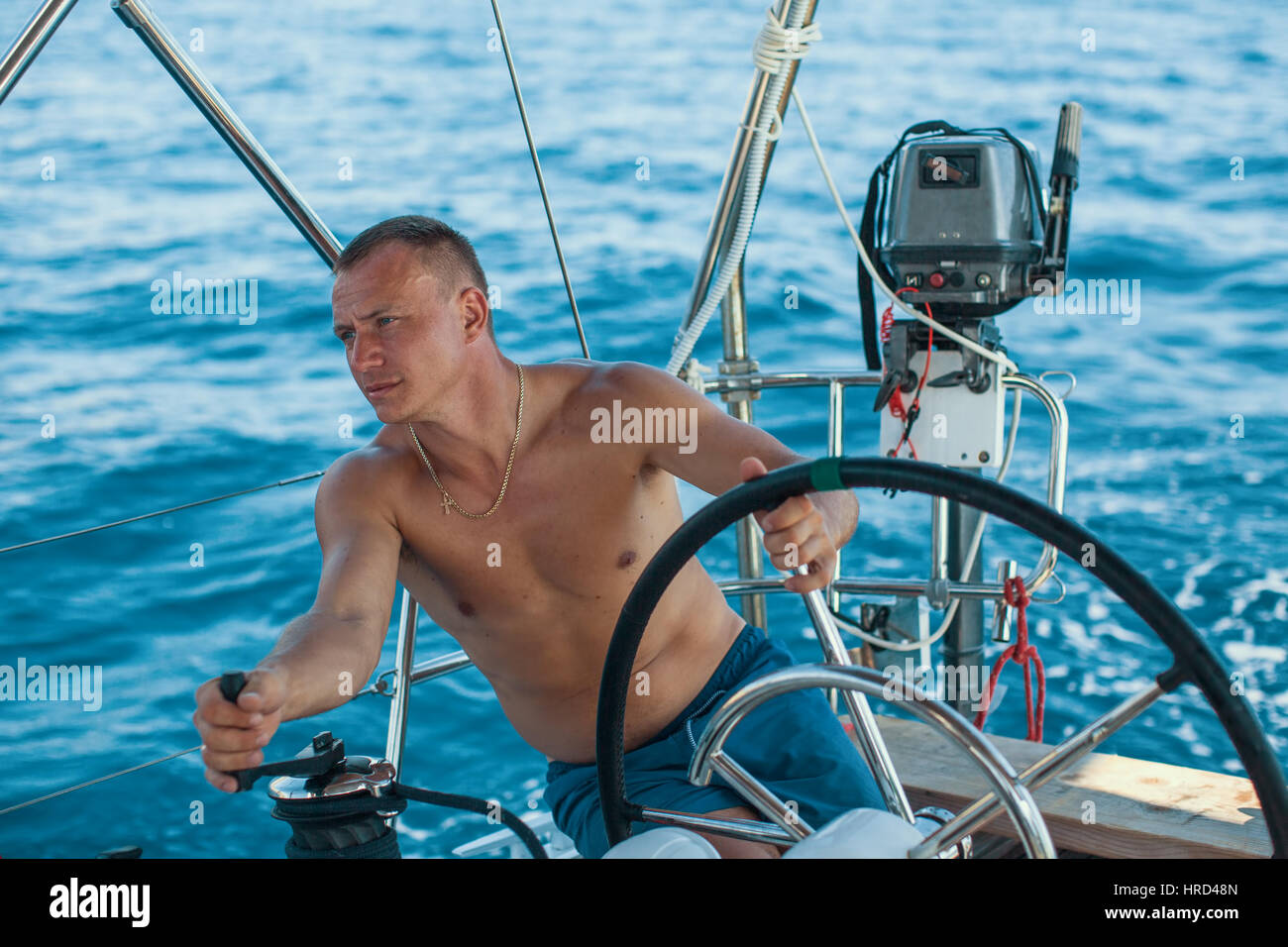Skipper man at the helm controls of a sailing yacht during sea boats ...