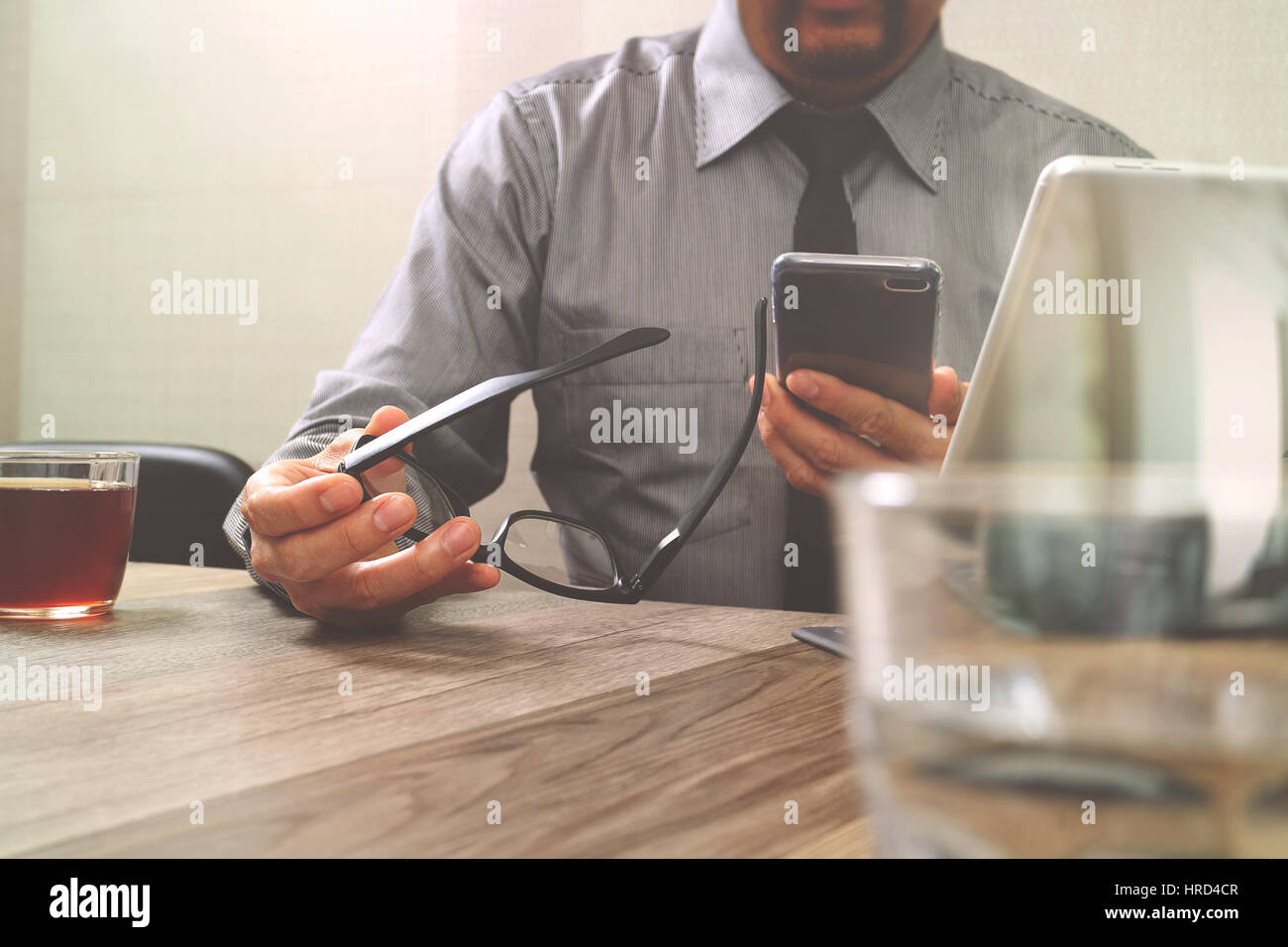 success businessman hand using eyeglass,smart phone,digital tablet docking smart keyboard on ...