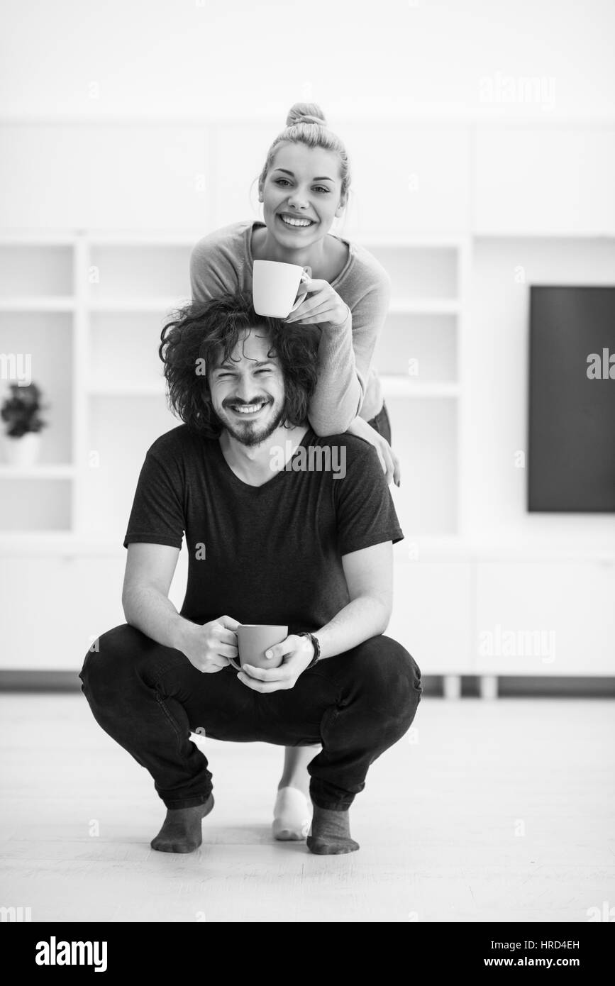 Portrait of a happy young beautiful couple hugging and drinking coffee ...