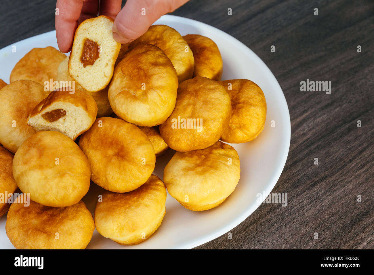 German donuts - berliner with jam and icing sugar in a tray on a dark ...