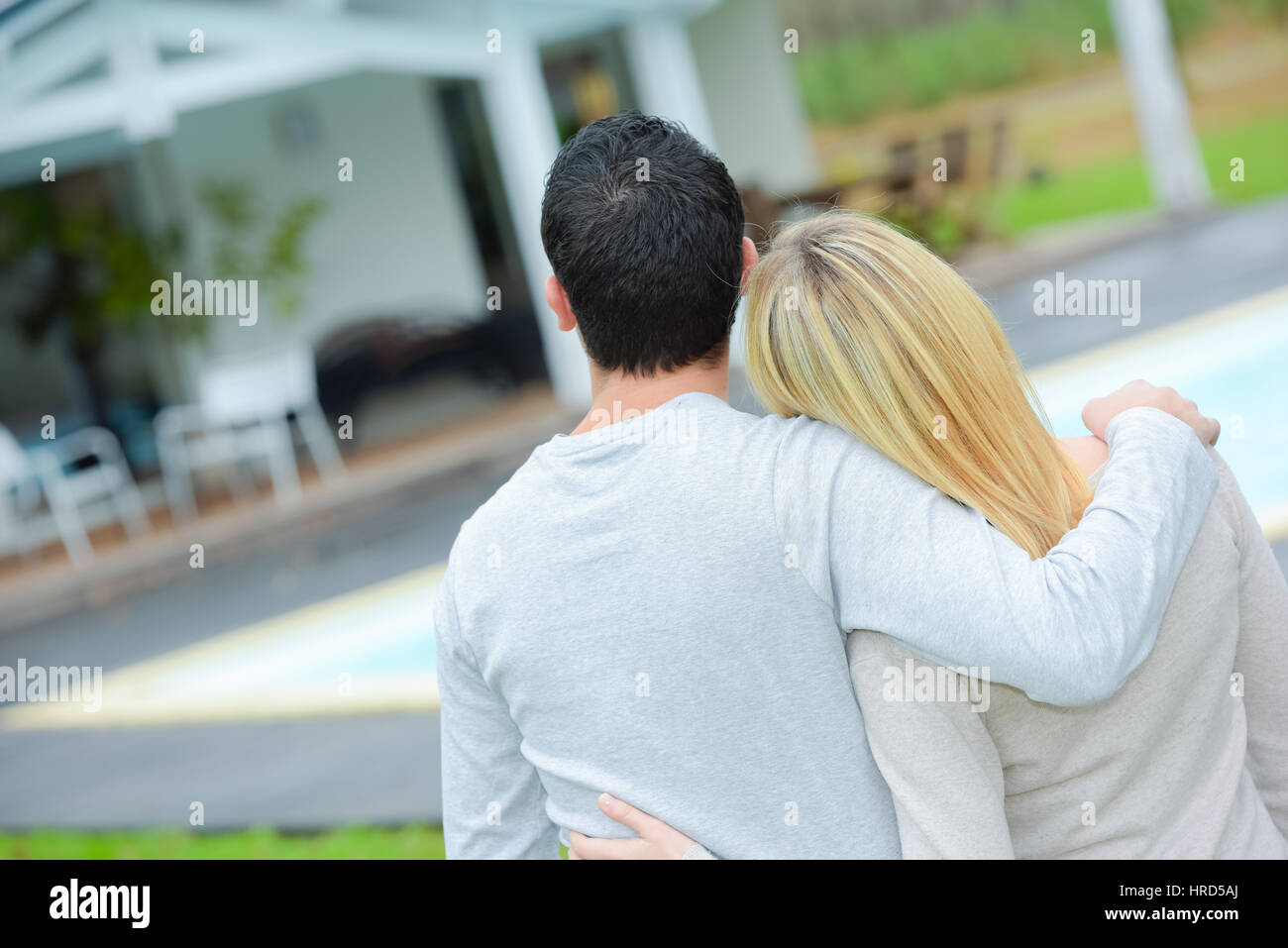 Couple hugging in front of their new house Stock Photo - Alamy