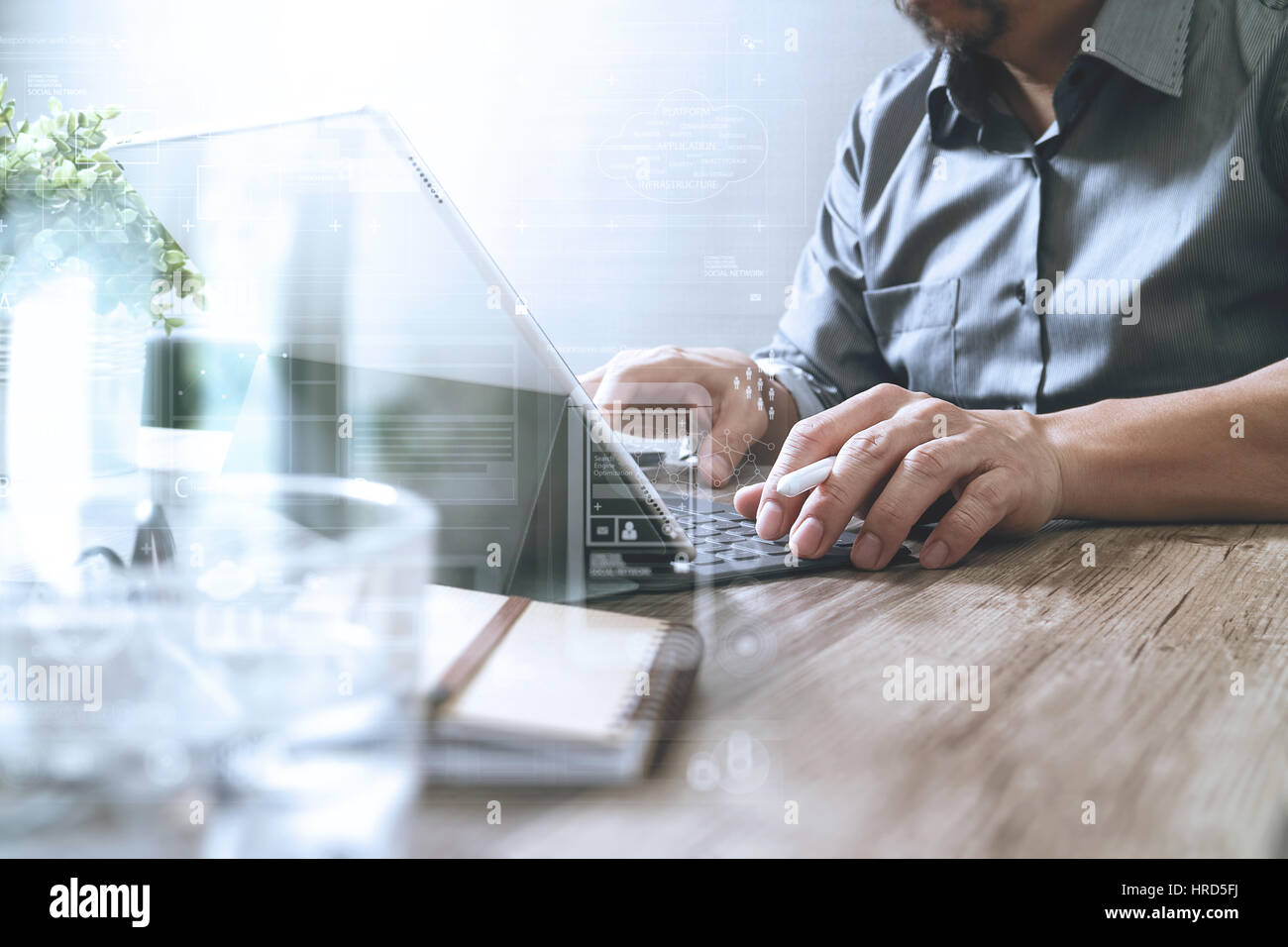 success businessman hand using stylus pen,digital tablet docking smart keyboard on wooden desk ...