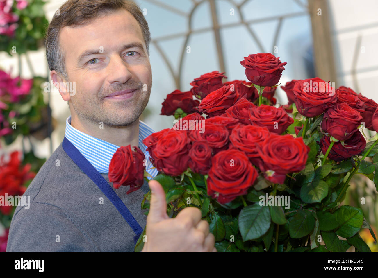Man with thumbs up, holding roses Stock Photo - Alamy