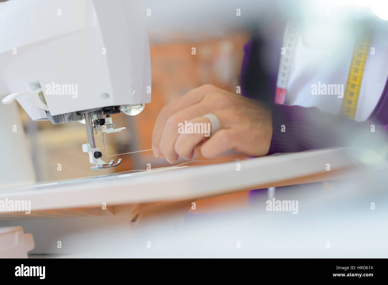 Closeup of woman threading needle on sewing machine Stock Photo - Alamy