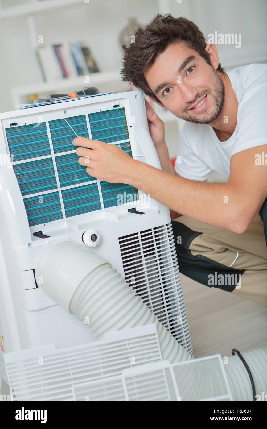 Portrait of man working on air conditioning unit Stock Photo - Alamy