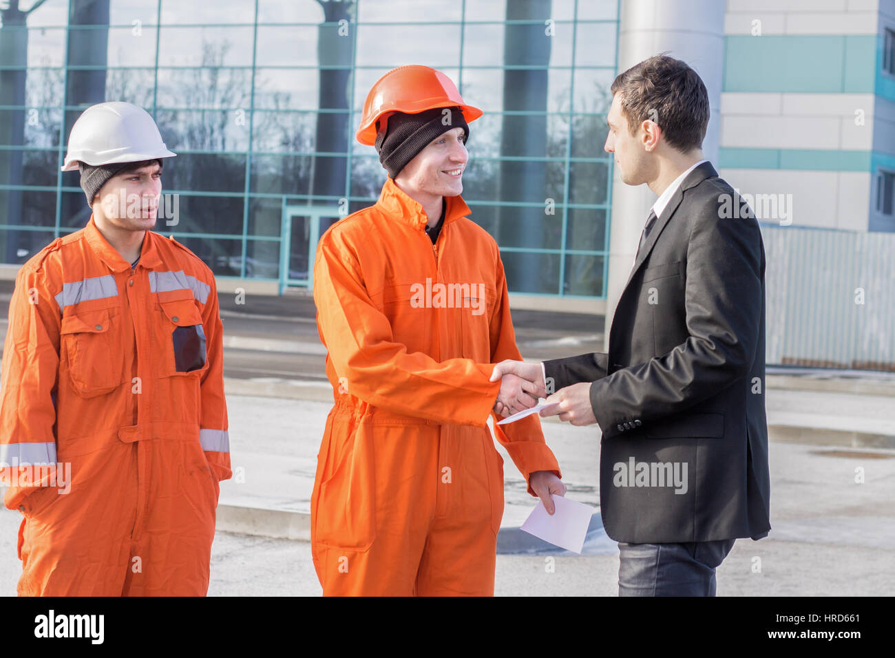 boss or Chief handshaking with workers engineers and giving salary in ...