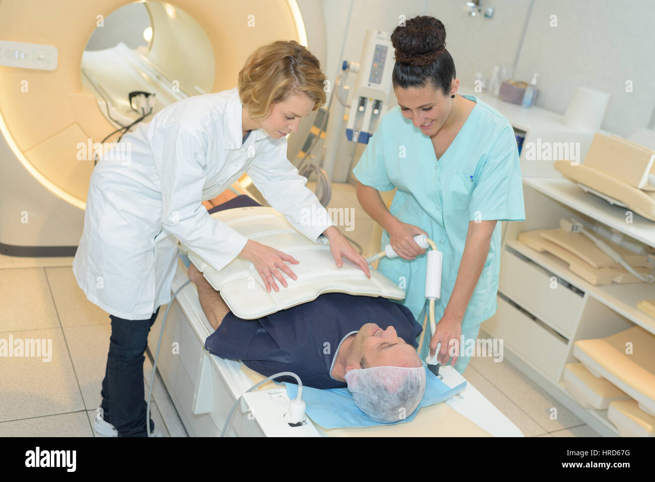 Nurses covering patient in preparation for scan Stock Photo - Alamy
