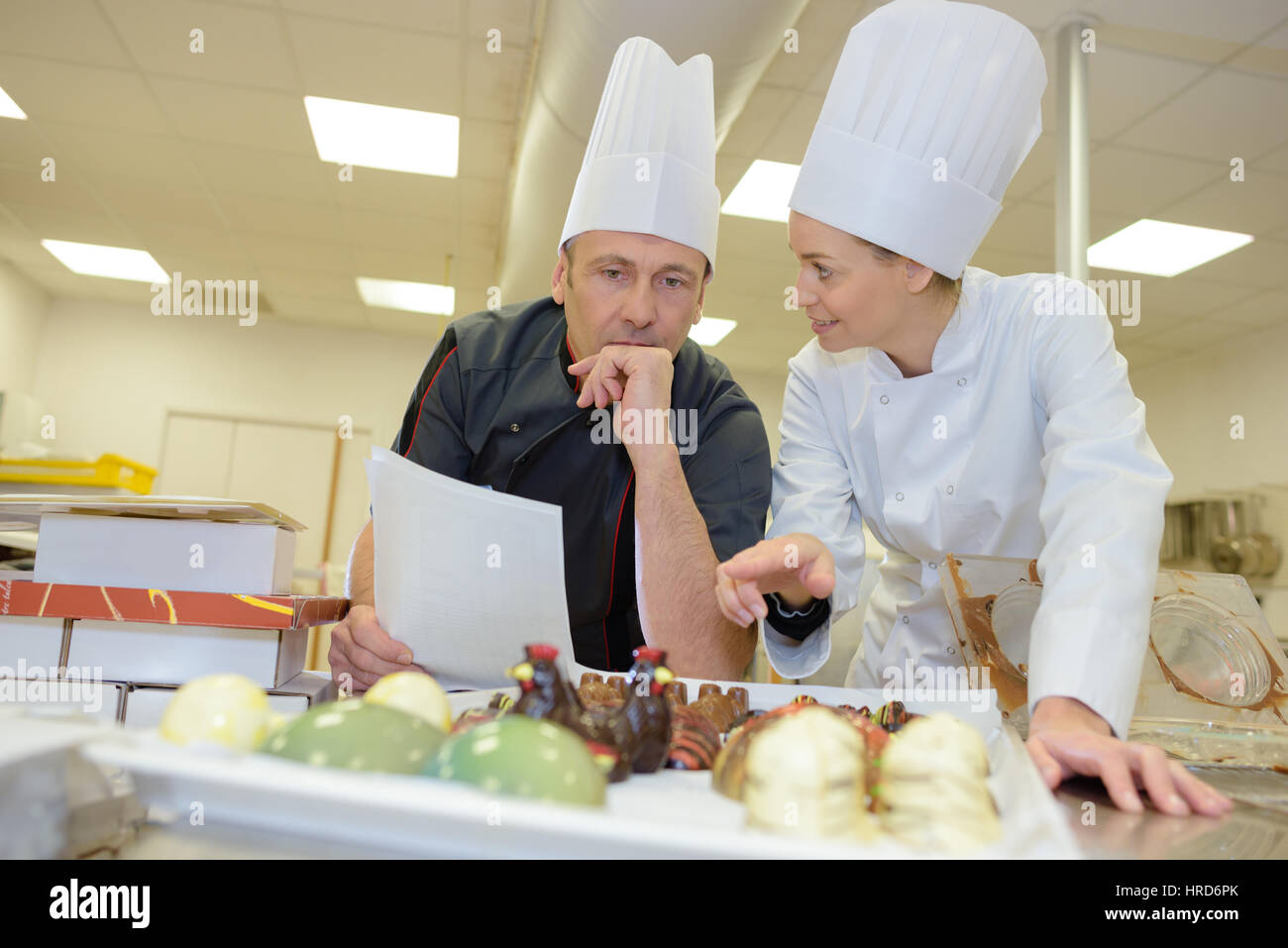 portrait of hospitable chef with young smiling female helper Stock ...