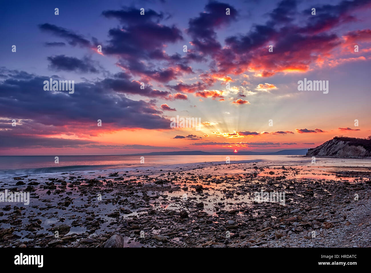 Amazing sea sunset with sun rays and water reflection Stock Photo - Alamy