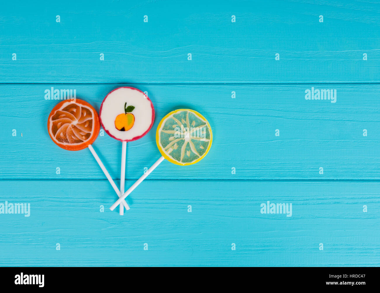 Small tasty round lollipops on wooden turquoise board Stock Photo - Alamy