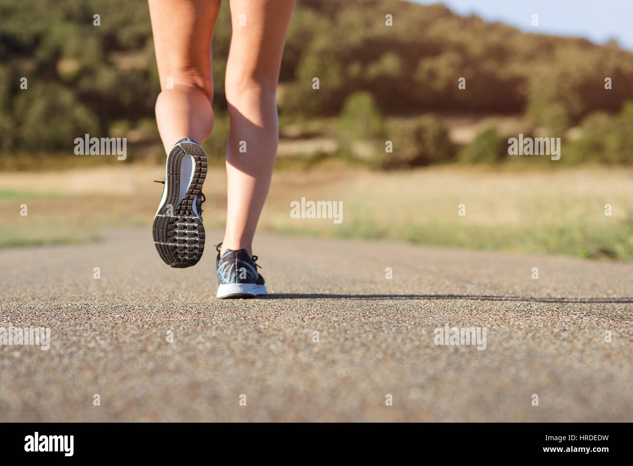 Girl running on the road Stock Photo - Alamy