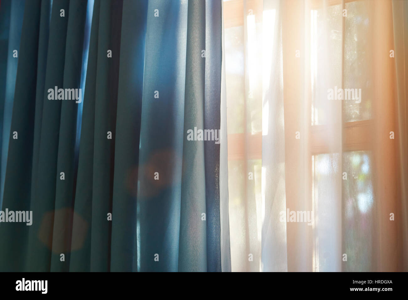 Window with curtain in sunny day closeup. Rays of sun coming throw ...