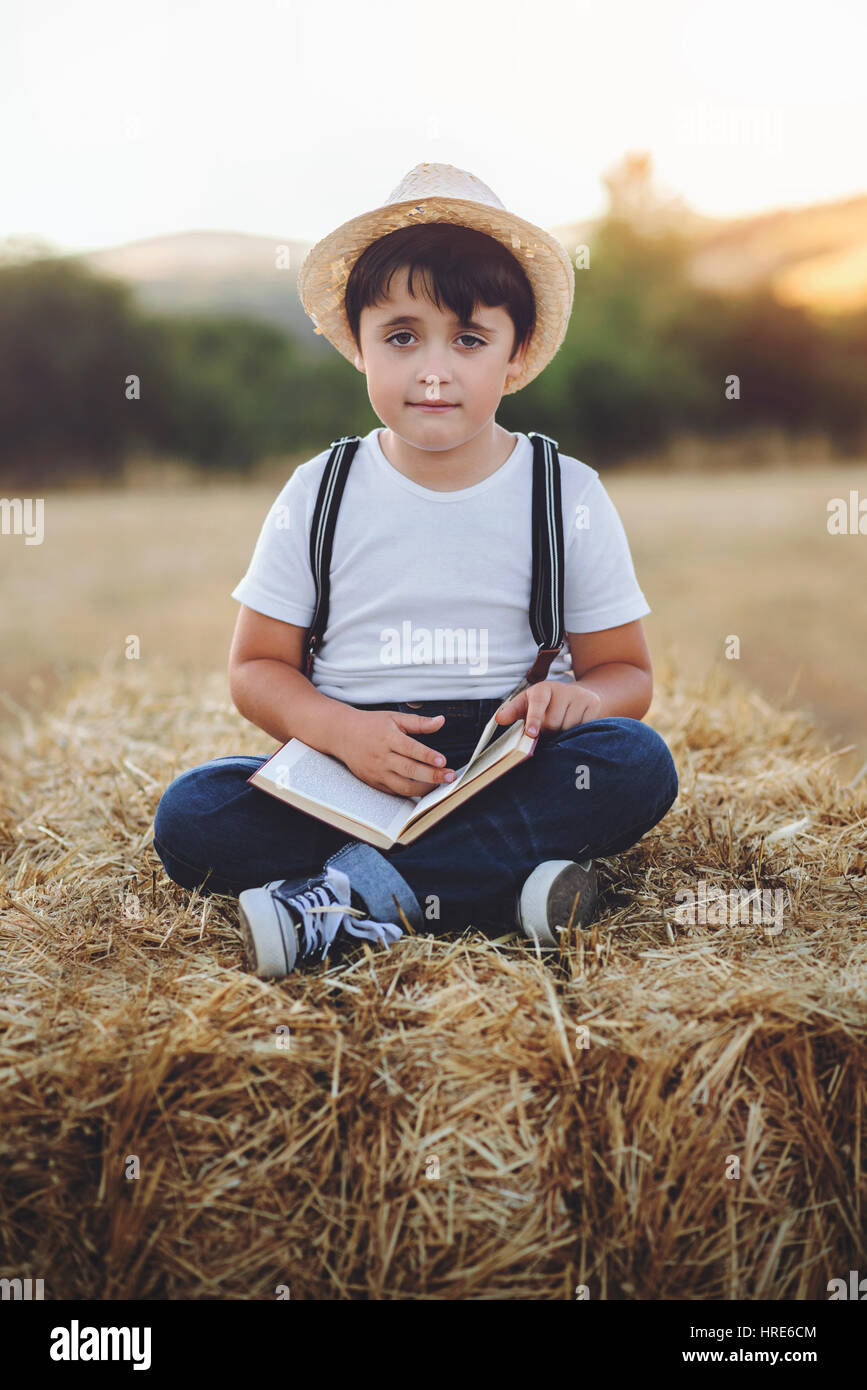 Boy reading a book in the field Stock Photo - Alamy