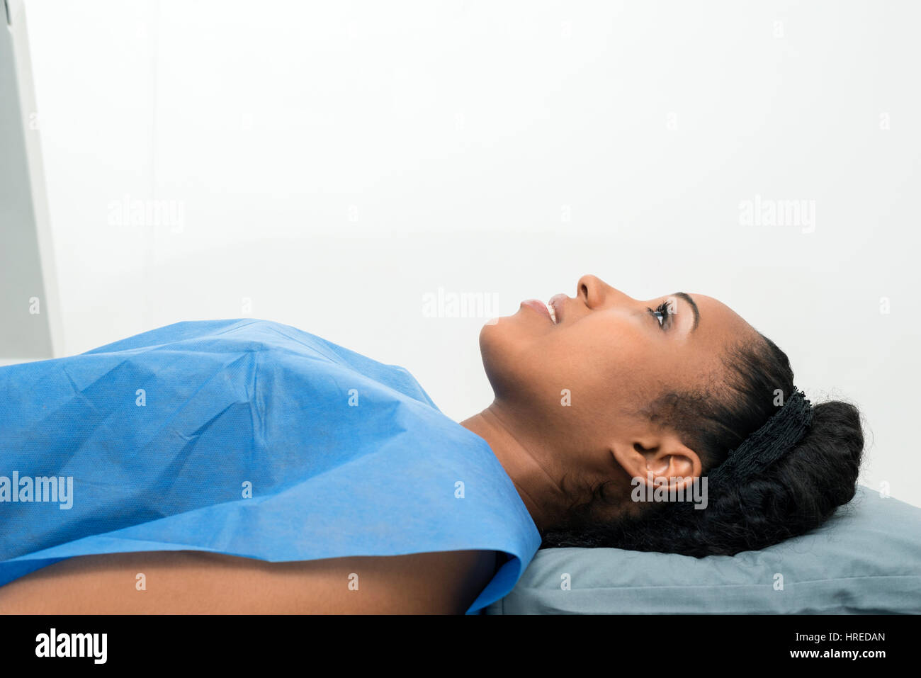 Side view of young female patient lying on bed in clinic Stock Photo ...